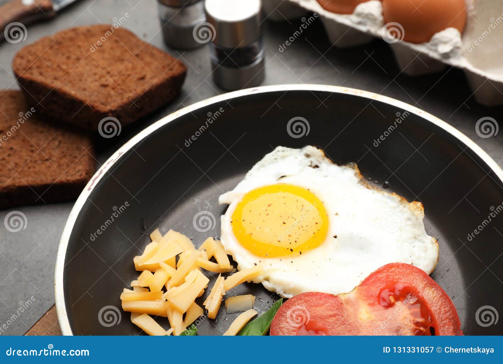 Pan with Fried Sunny Side Up Egg, Cheese and Tomato on Table Stock ...