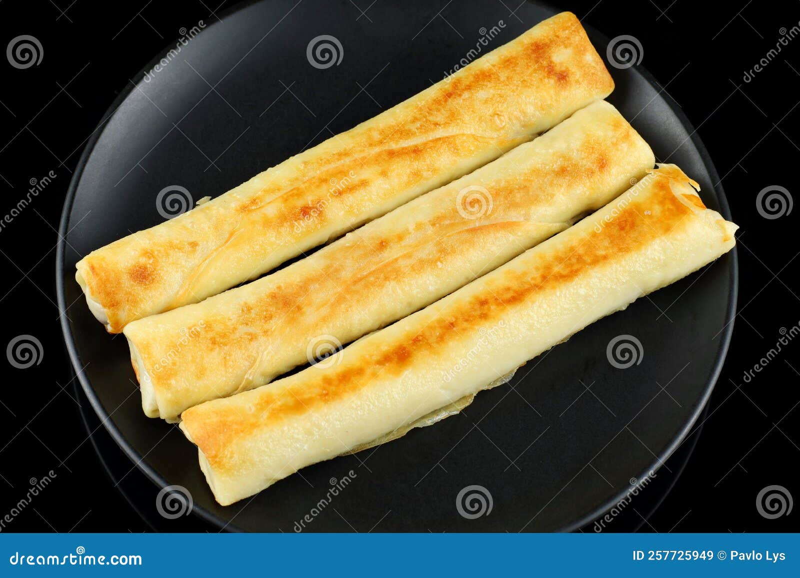 Pancakes Rolls on a Black Plate. Stuffed Thin Pancakes Rolled Stock ...