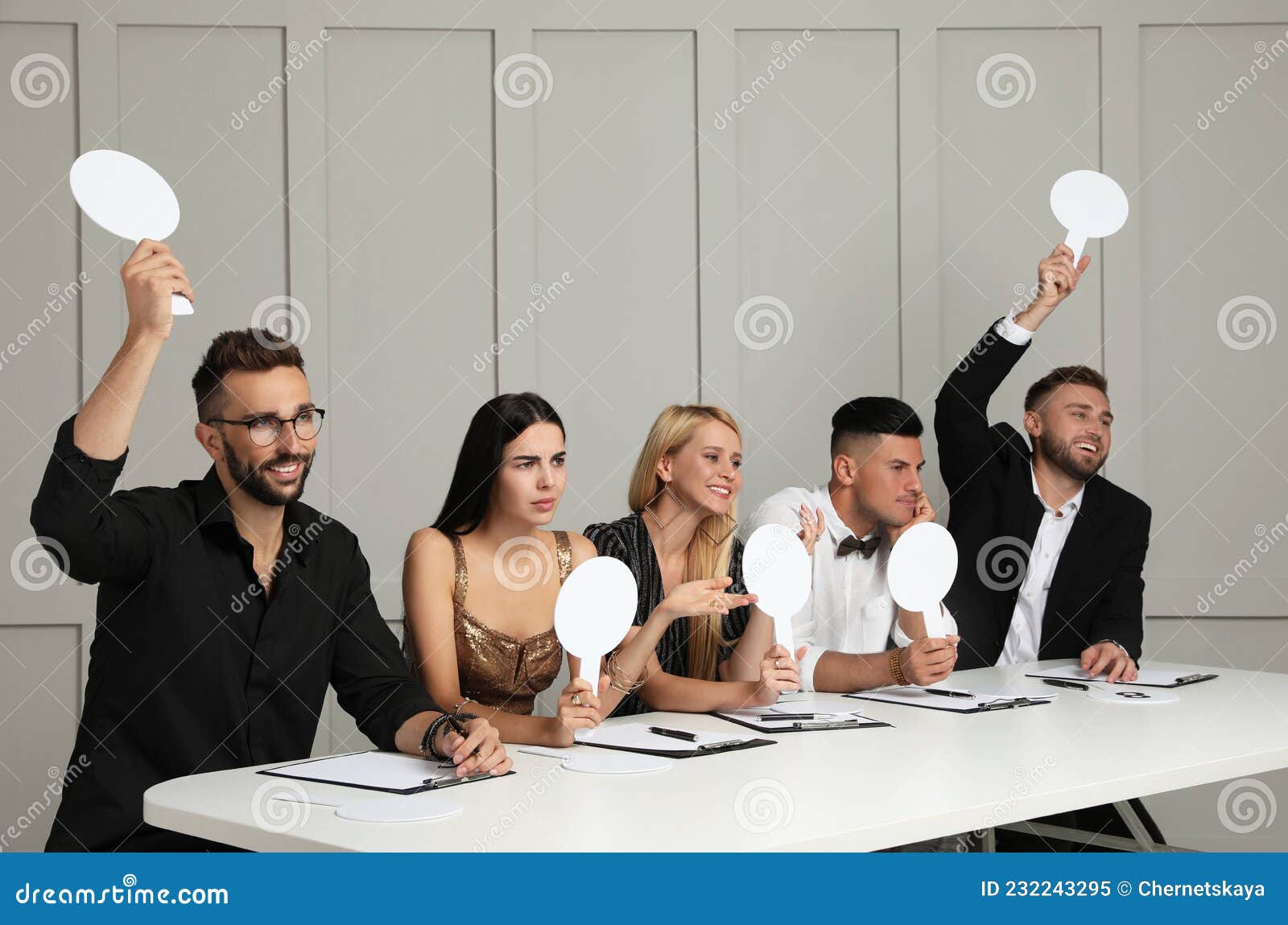 Panel of Judges with Different Emotions Holding Blank Score Signs at ...