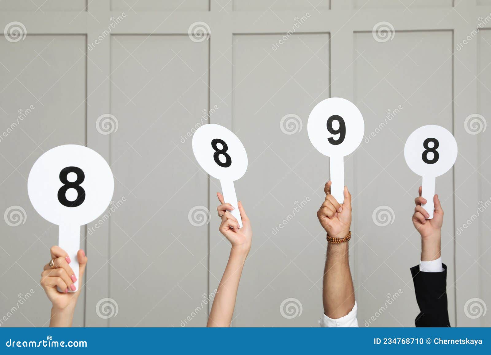 Panel of Judges Holding Different Score Signs Against Light Wall ...