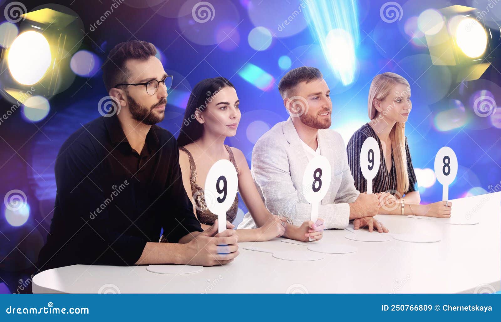 Panel of Judges Holding Different Score Signs at Table Against Blurred ...