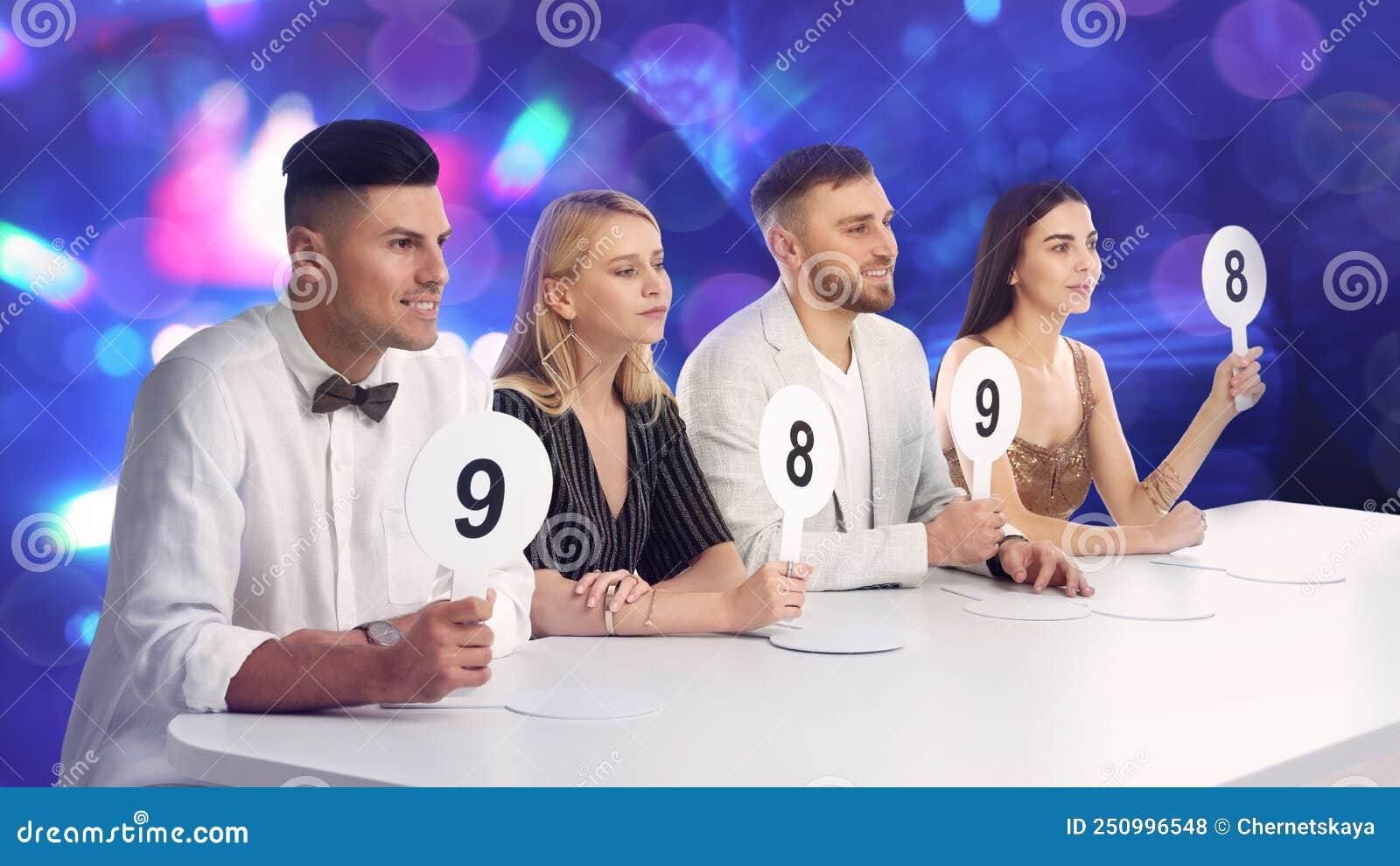 Panel of Judges Holding Different Score Signs at Table Against Blurred ...