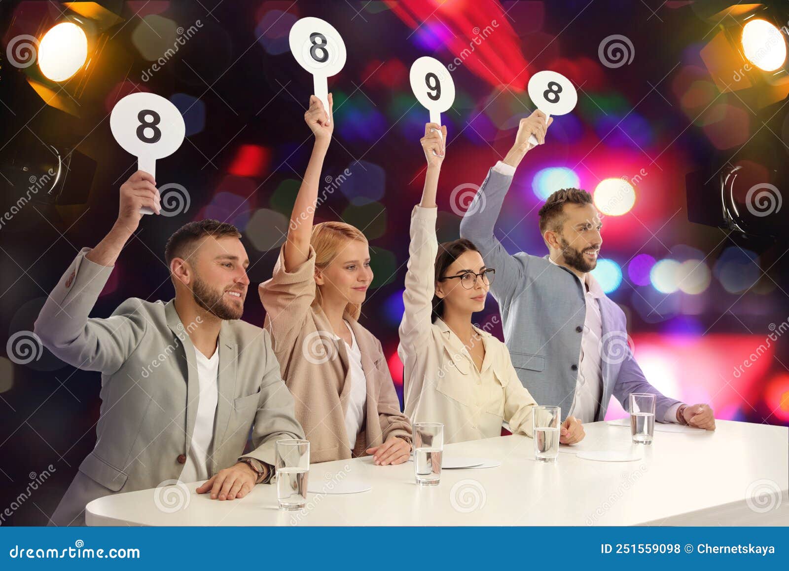 Panel of Judges Holding Score Signs at Table Against Blurred Background ...