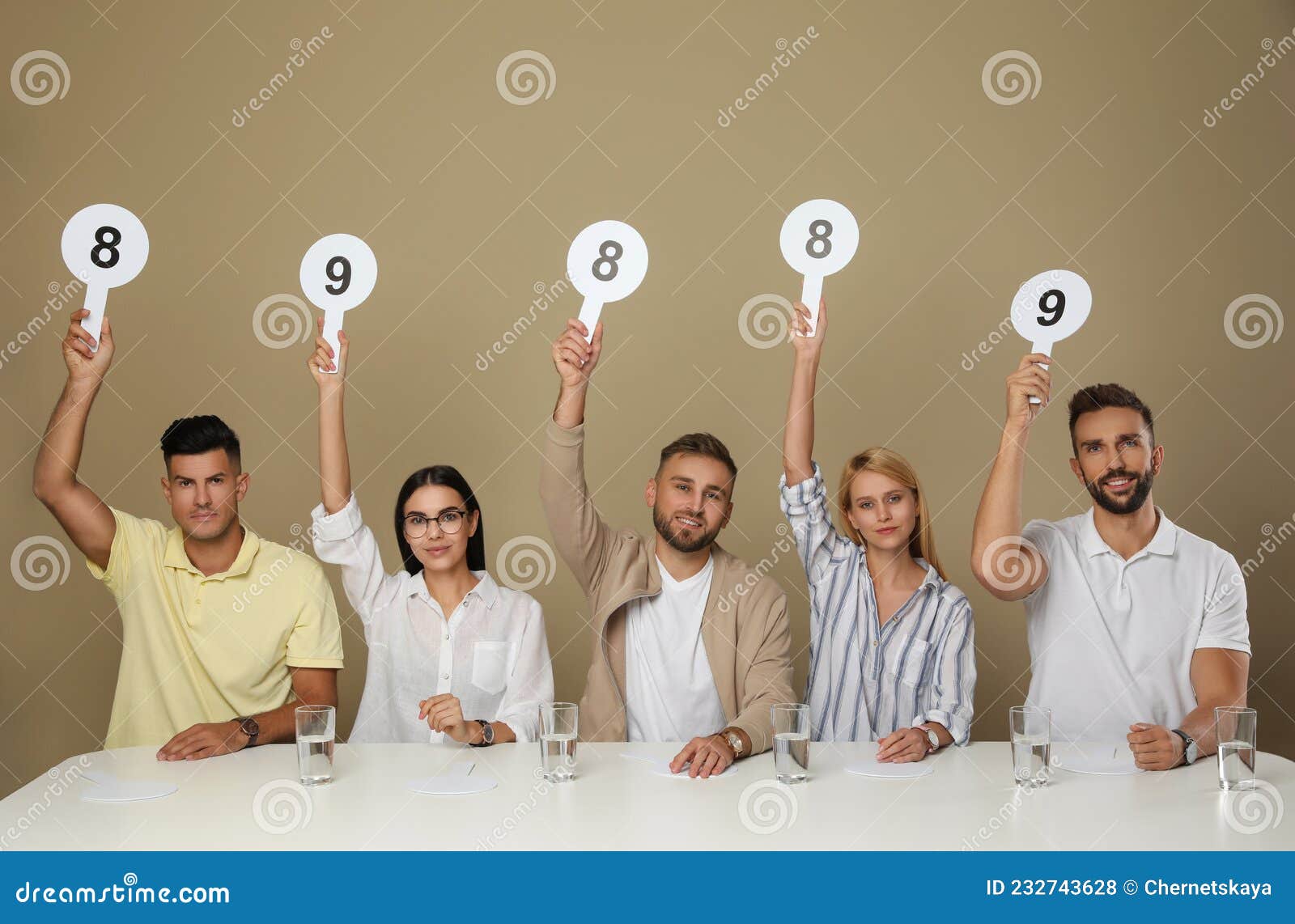 Panel of Judges Holding Different Score Signs at Table on Beige ...