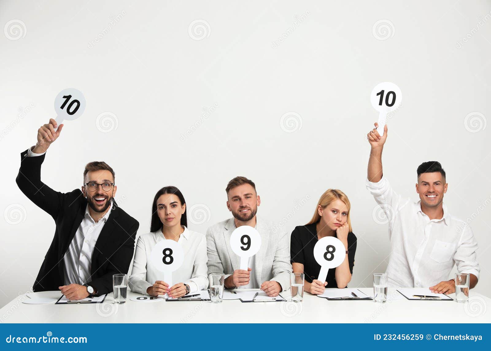 Panel of Judges Holding Different Score Signs at Table on White ...