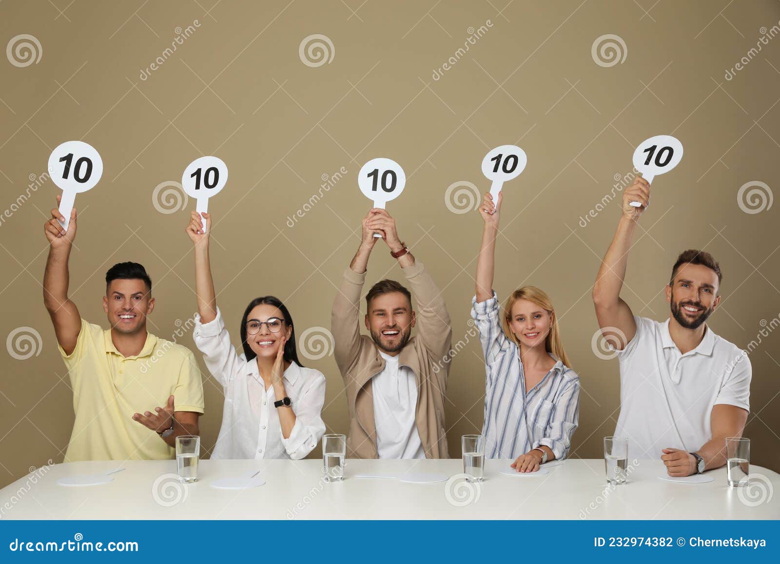 Panel of Judges Holding Signs with Highest Score at Table on Beige ...