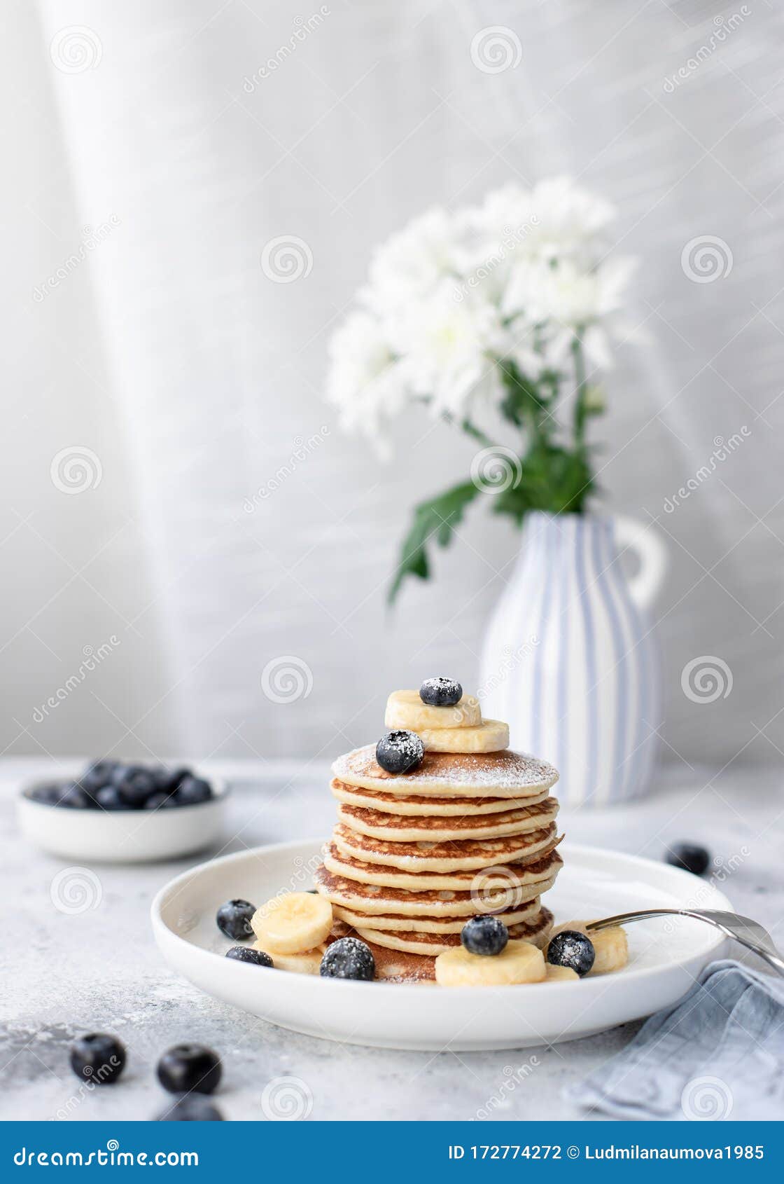 Panksjöar Med Blåbär Och Bananer På Ett Bord Med Blommor I En Vase ... Panksjöar Med Blåbär Och Bananer På Ett Bord Med Blommor I En Vase ...