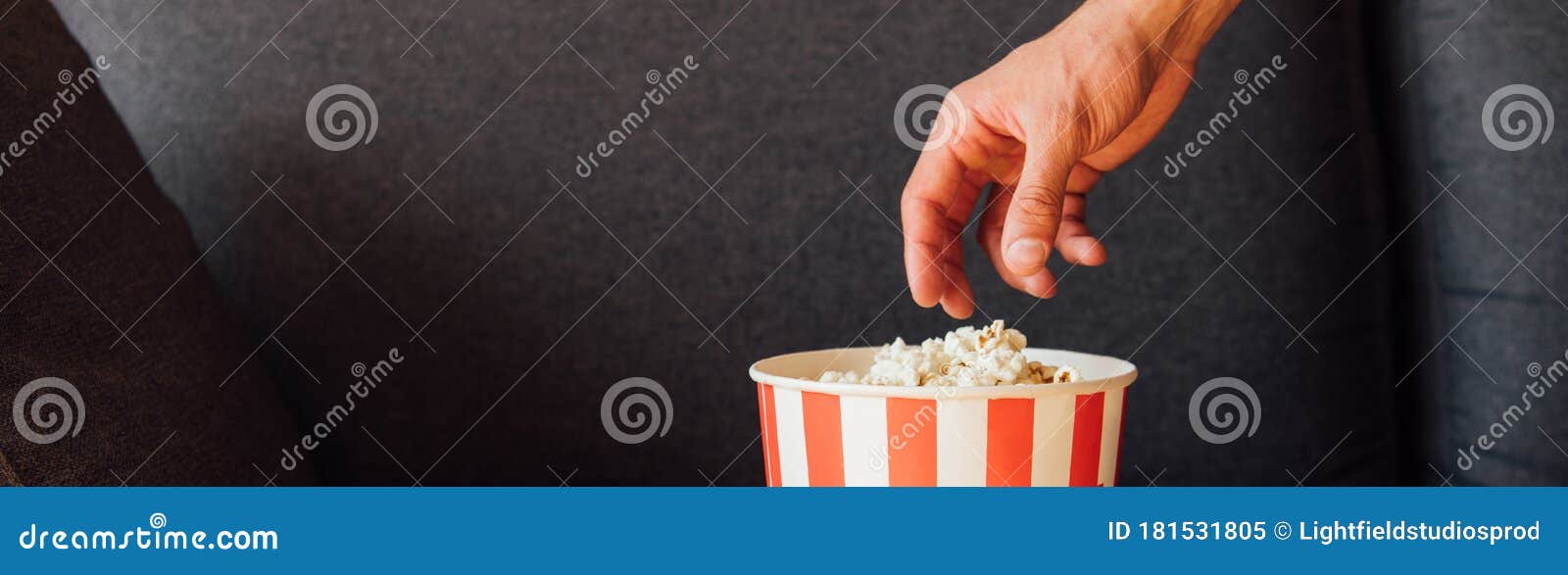 Crop of Man Reaching Popcorn in Bucket Stock Image - Image of sofa ...