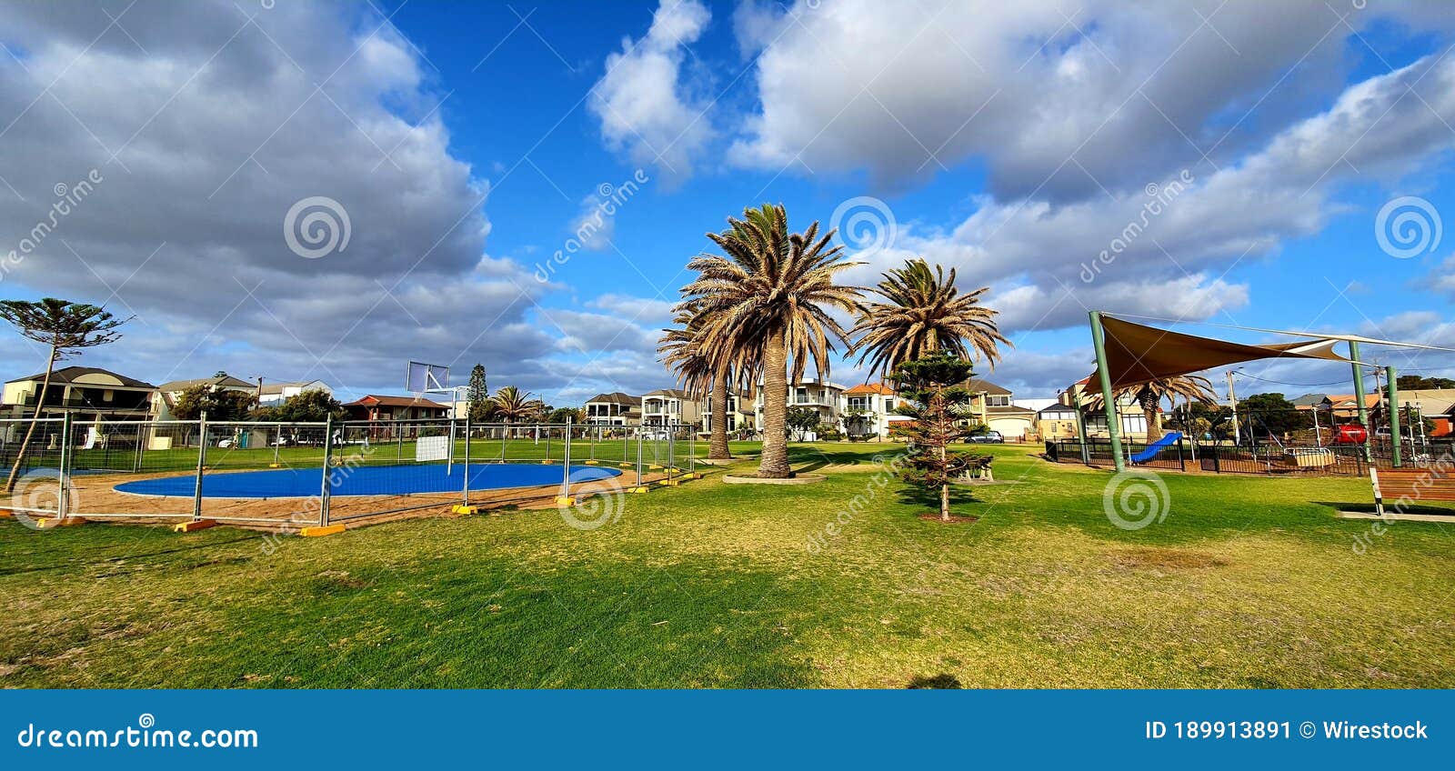 Panoramic Shot of a Park with Palm Trees and a Playground Under a Blue ...