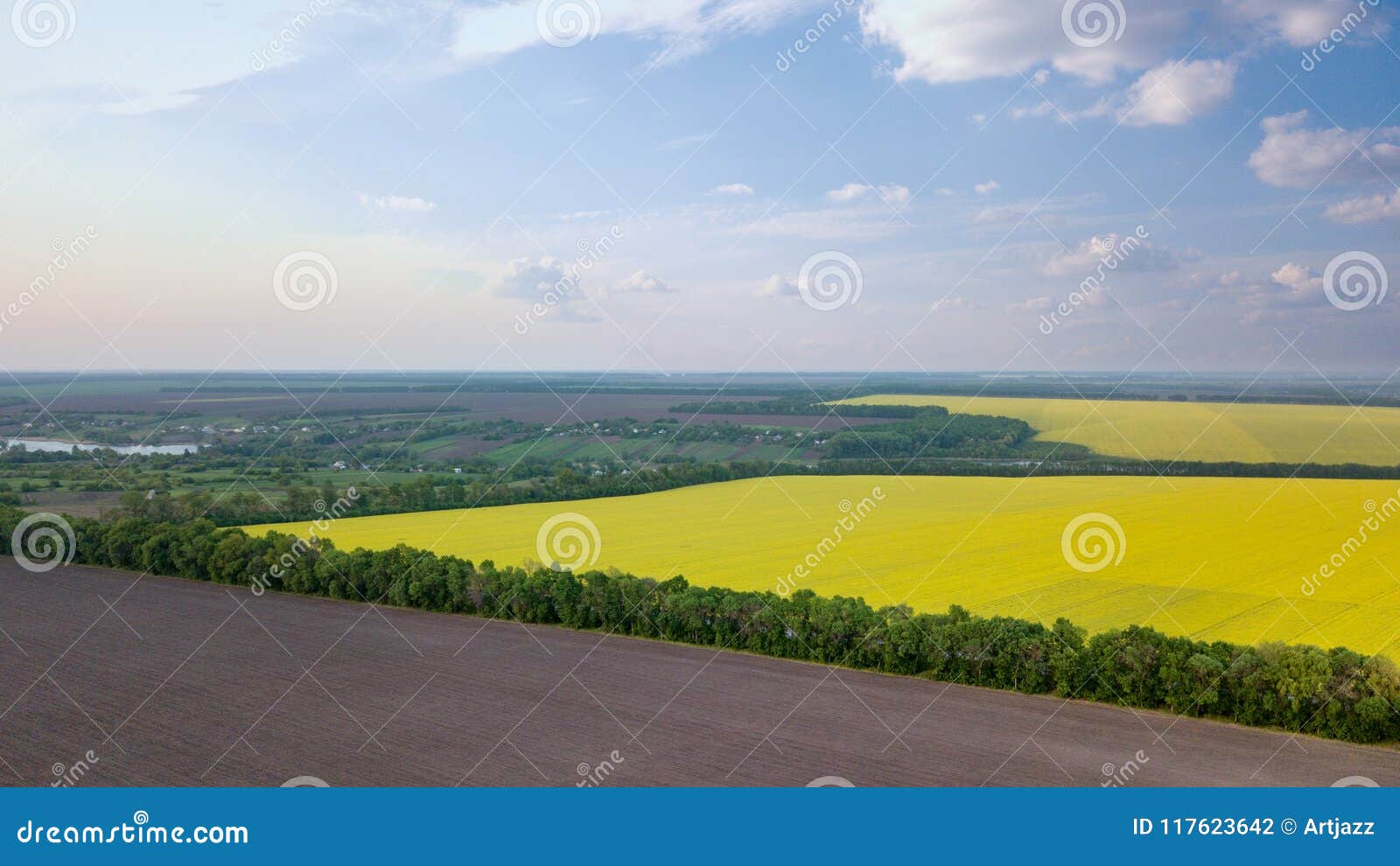 Panoramic View of a Field and a Village in the Distance Against a Blue ...