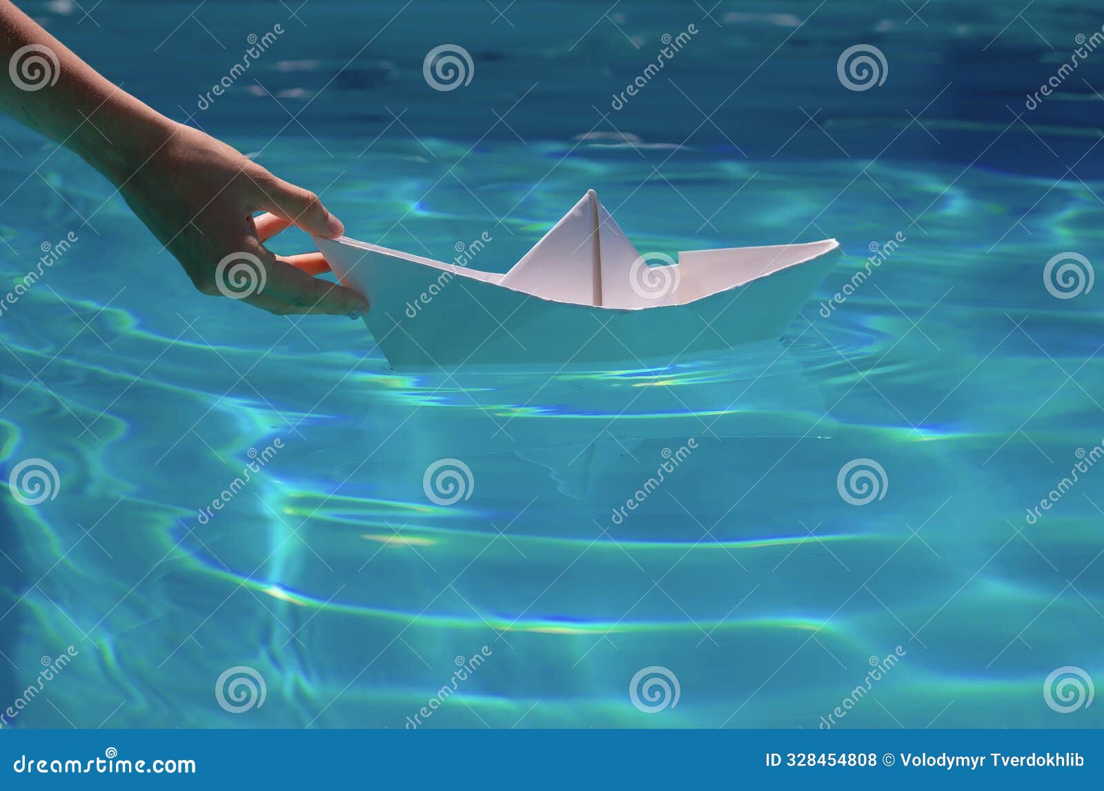Paper Boat Sailing on Water Causing Waves and Ripples. Hand Putting a ...