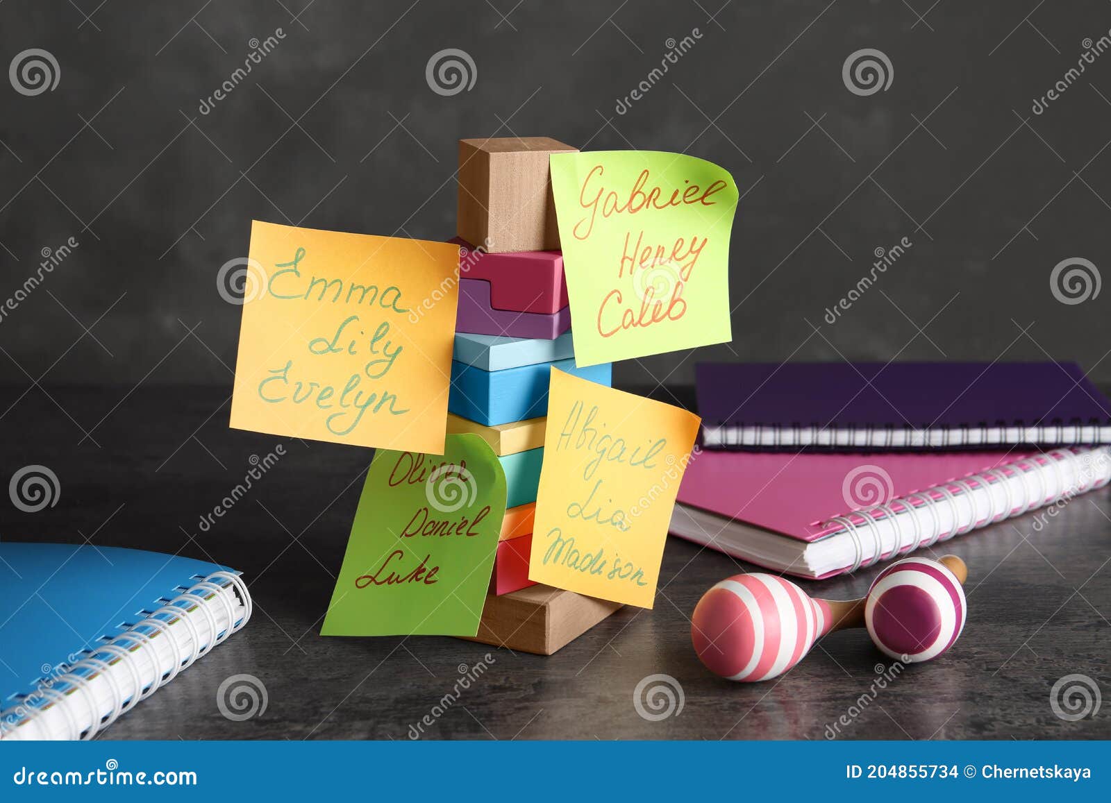 Paper Notes with Different Baby Names, Toys and Notebooks on Grey Table ...