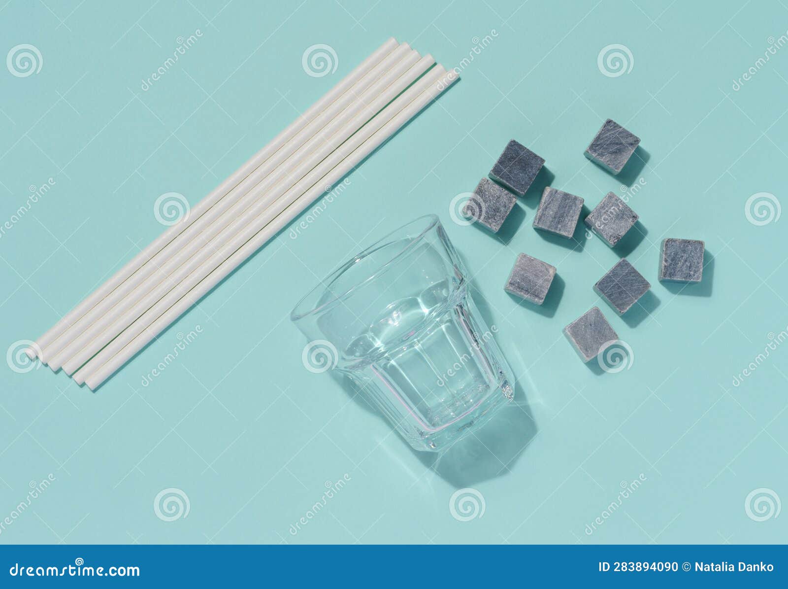 Paper Straws, an Empty Glass and Stone Ice Cubes on a Blue Background ...
