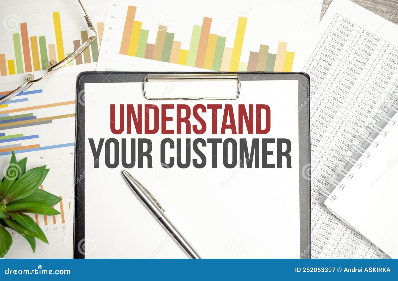 Paper with UNDERSTAND YOUR CUSTOMER on a Table with Charts, Glasses and ...
