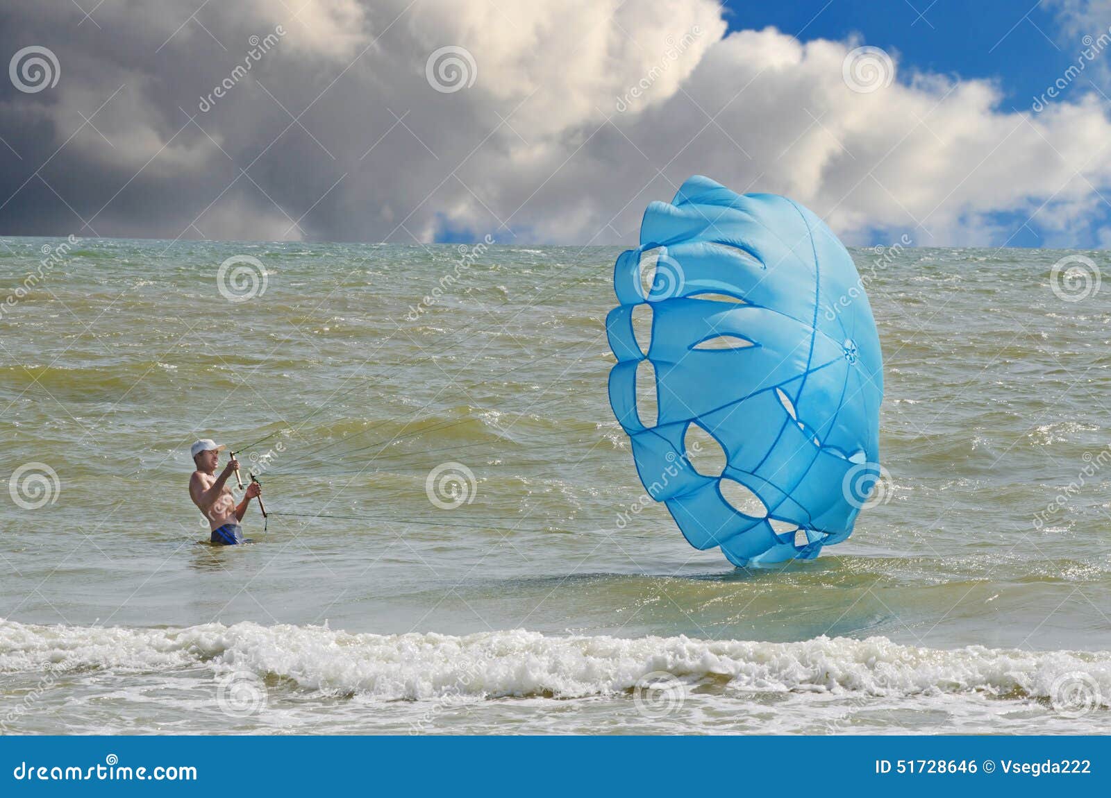 Parachuting. the Man in the Blue Sea Keeps Parachute in the Wind Stock ...