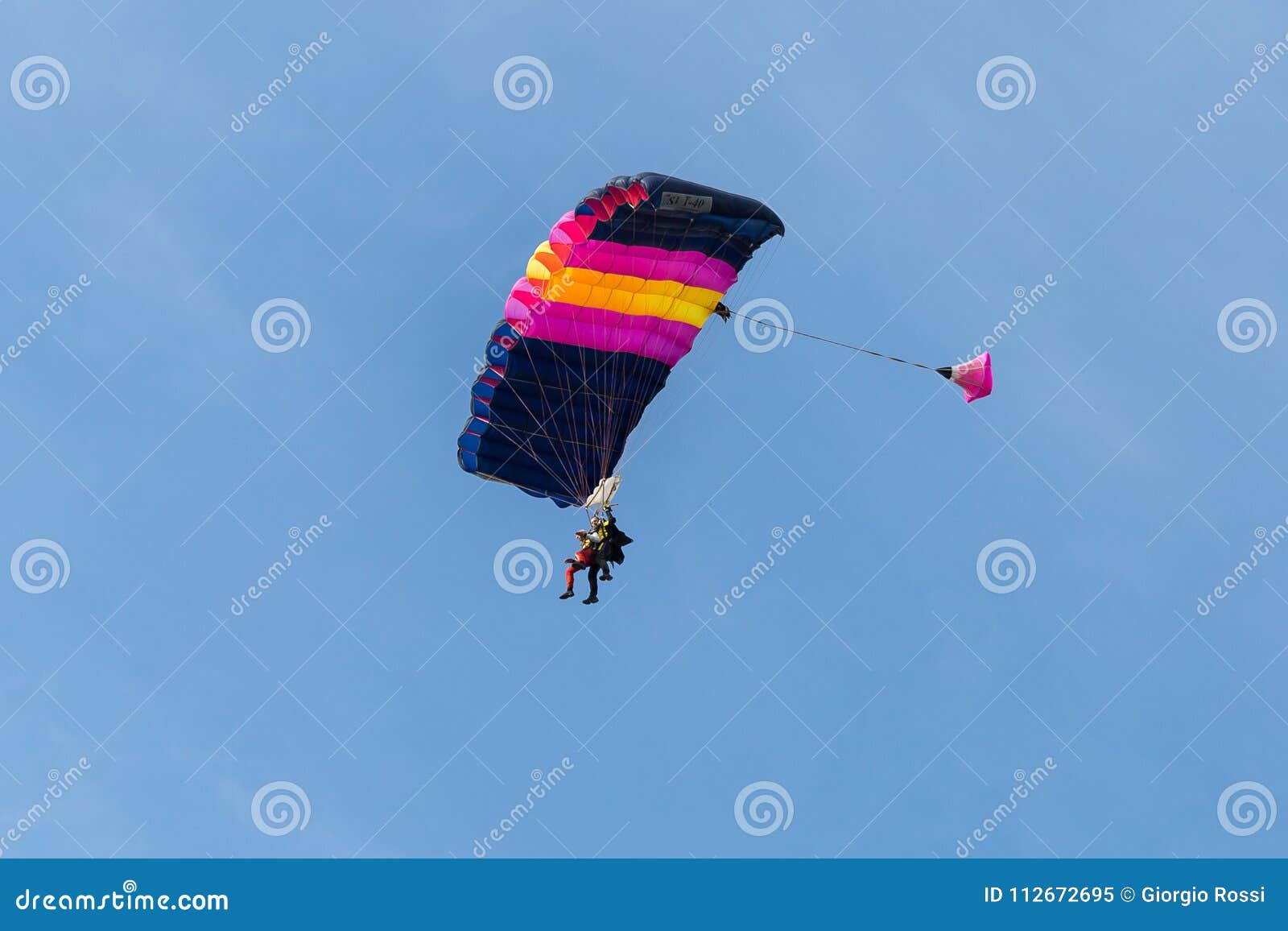 Parachutists: Instructor and Beginner with Blue Parachute Against Clear ...