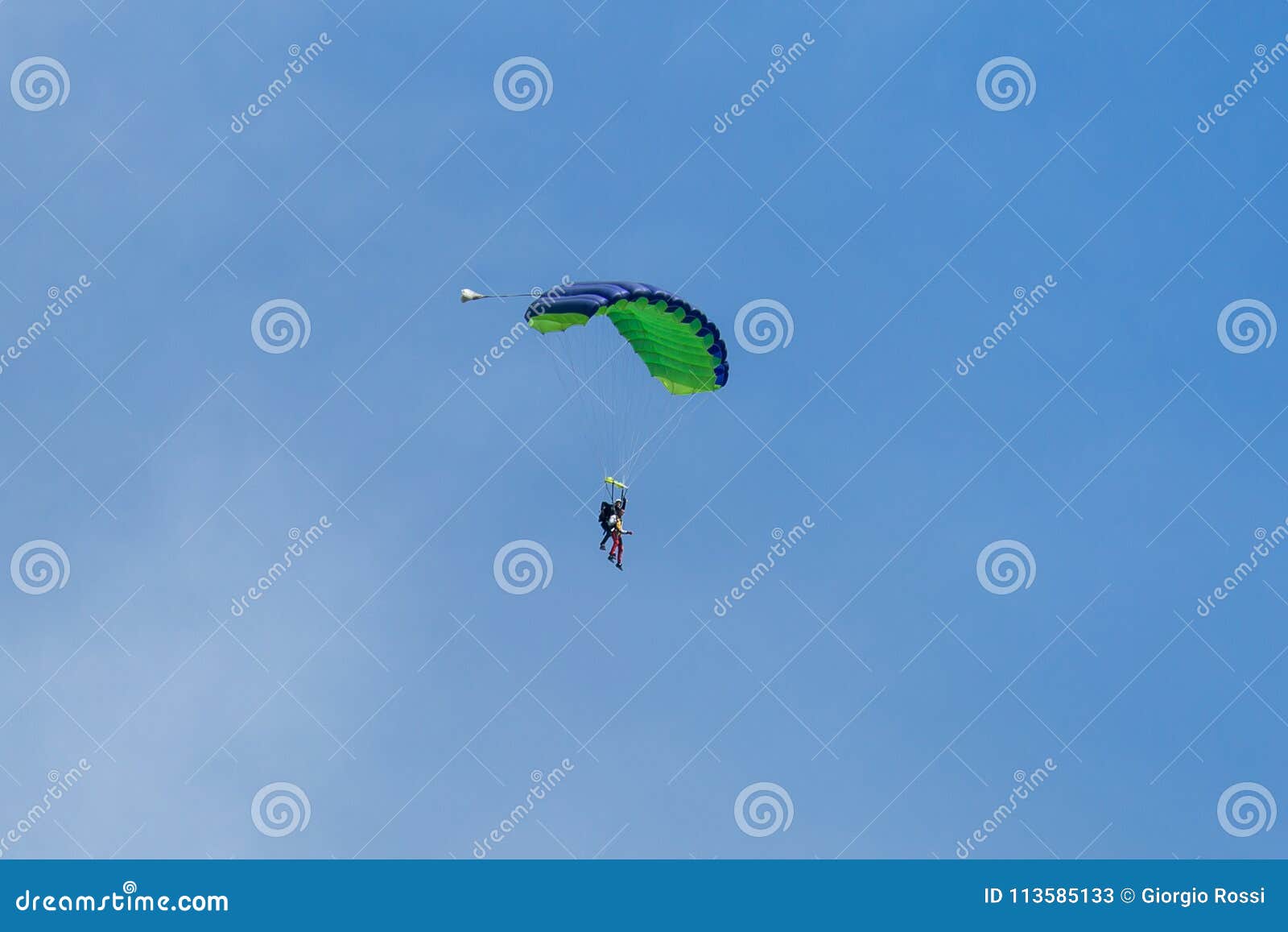 Parachutists: Instructor and Beginner with Green Parachute Against ...