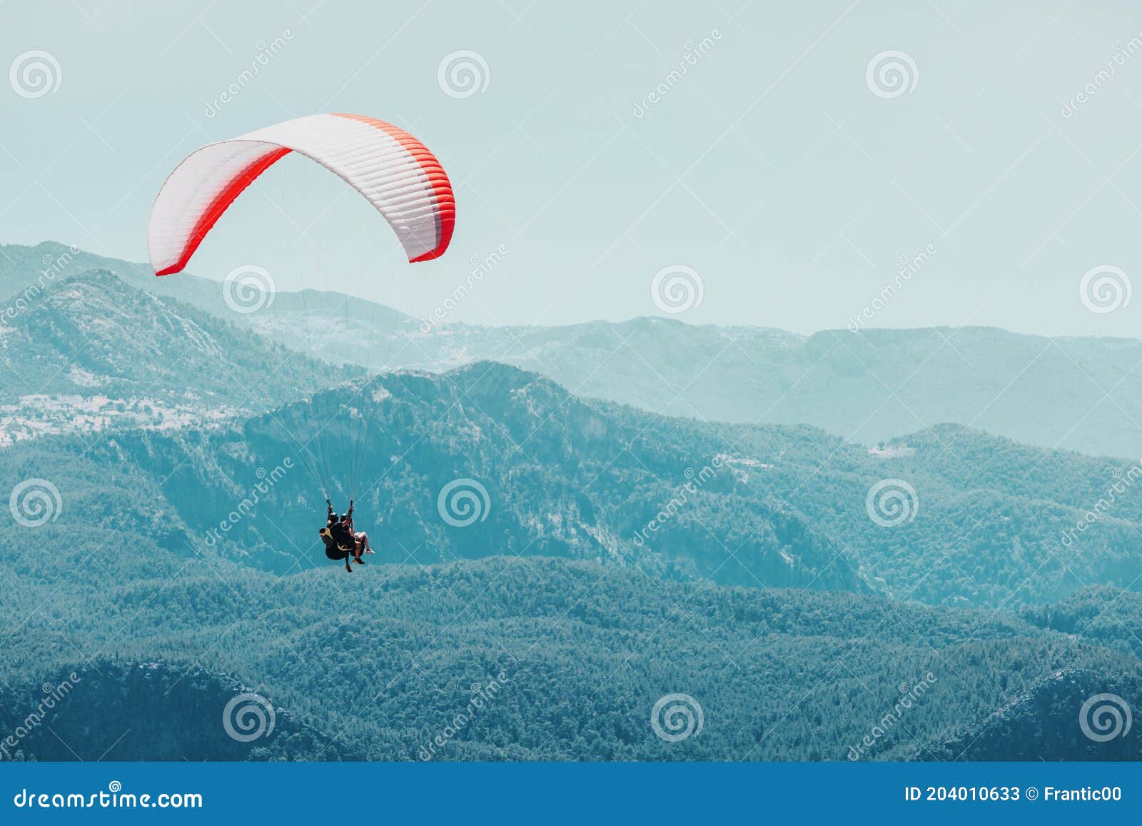 Paraglider with an Instructor and a Student Soars Against the ...