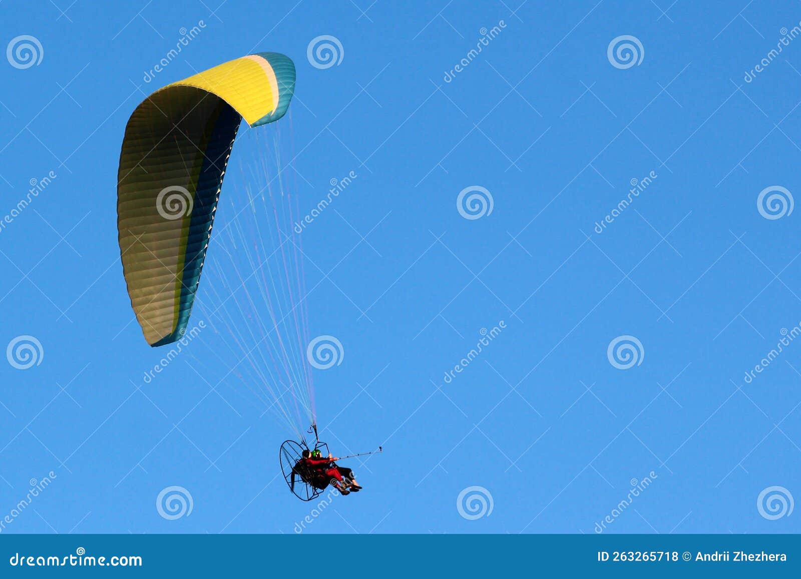 Paragliding in a Blue Sky, Pilot Controls Motorized Flying Machine ...