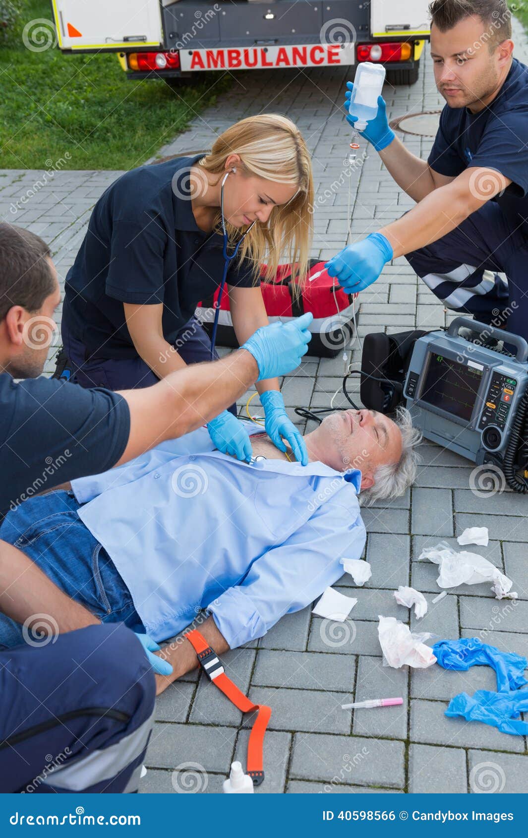 Paramedics Examining Unconscious Man Stock Photo - Image of ground ...