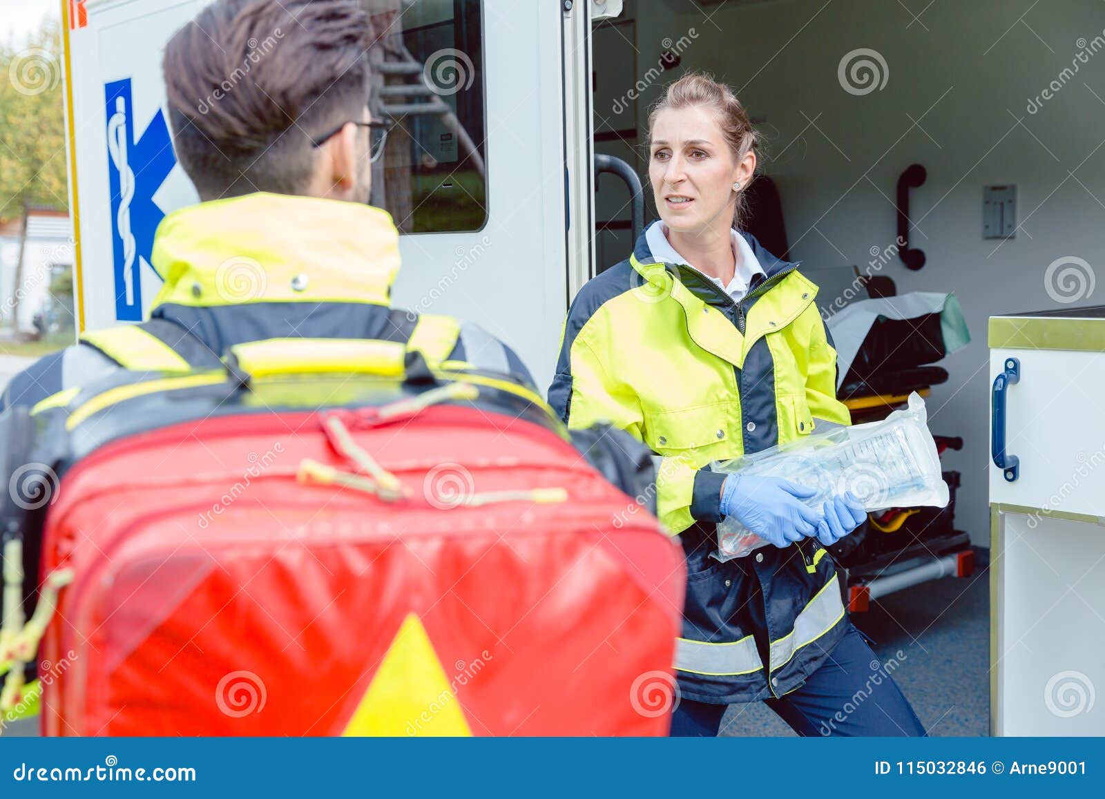 Paramedics in Front of Ambulance Discussing Deployment Stock Photo ...