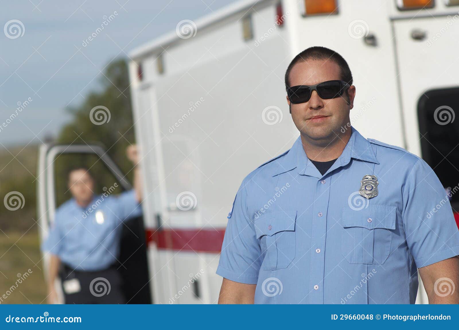 Paramedicus in Front of Ambulance Stock Foto - Image of zonnebril ...