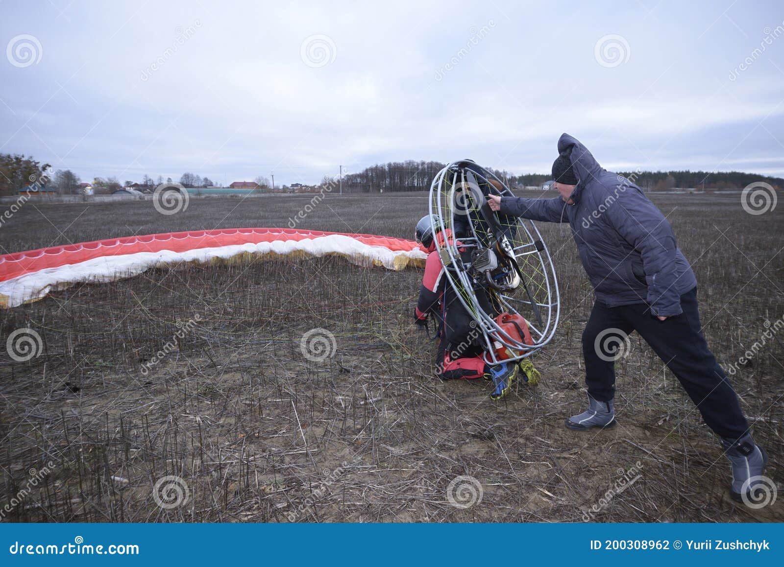 Paramotoring. Instructor Starting the Engine of Paramotor by Turning ...