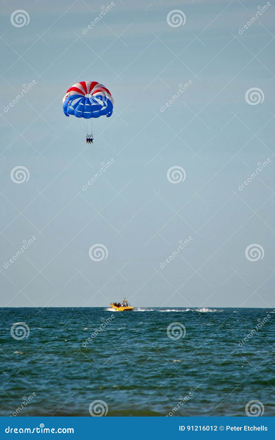 Parasailing, A Red And White Boat Pulls A Blue Parachute With A Smiley ...