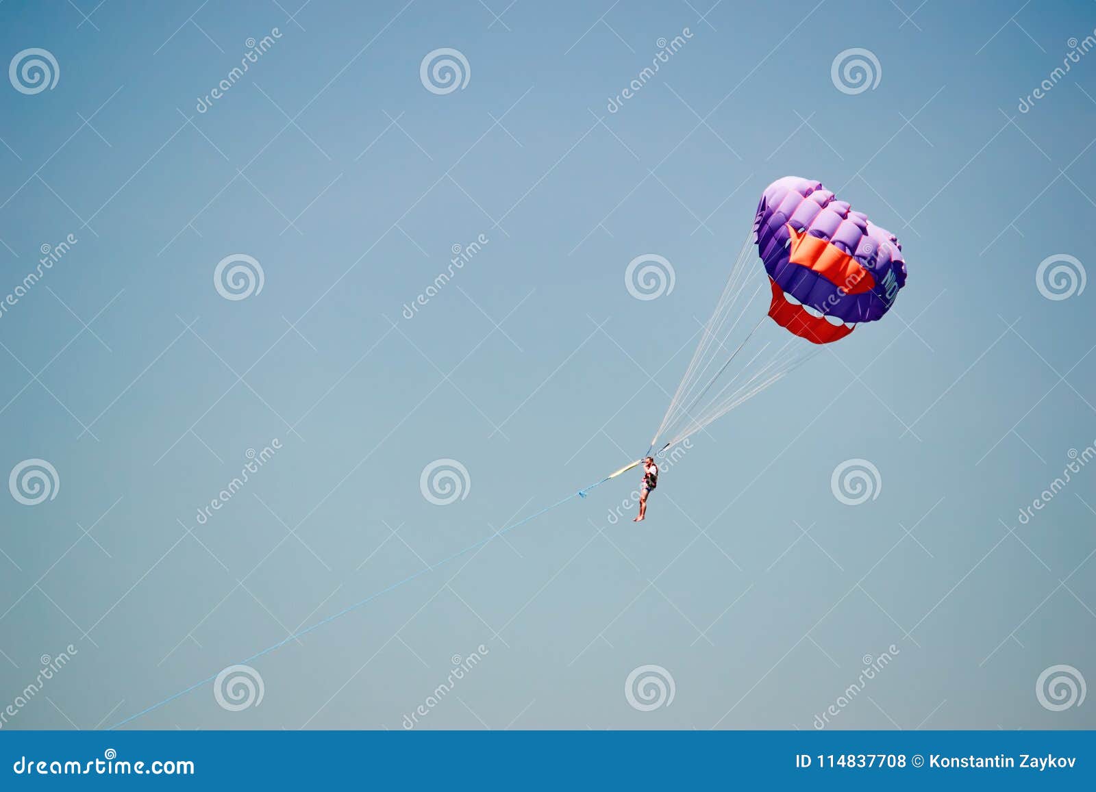 Parasailing. Man Flies on Parachute in Clear Blue Sky. Side View. Copy ...