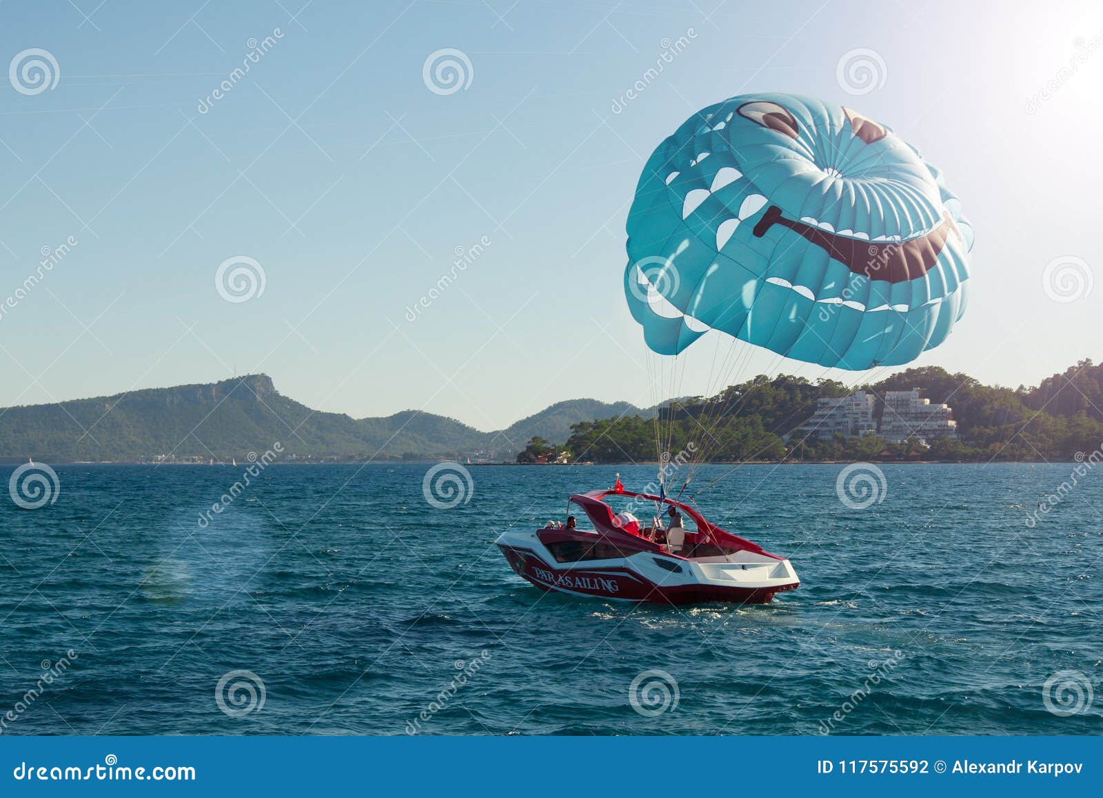 Parasailing, a Red and White Boat Pulls a Blue Parachute with a Smiley ...