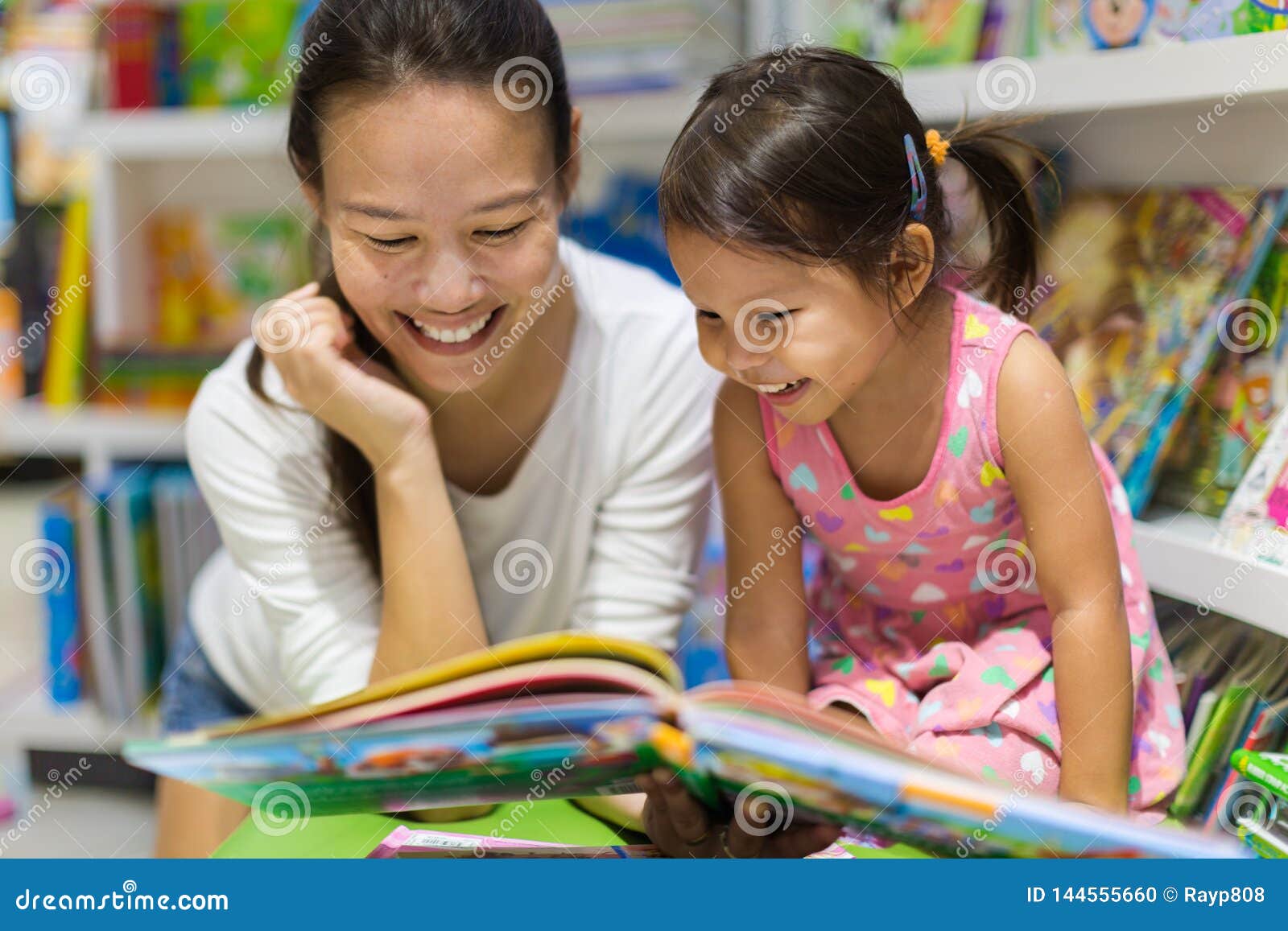 Parent and Child Reading Books Together in the Library Stock Photo ...