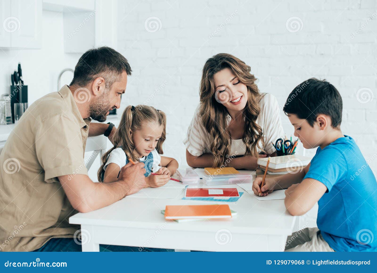 Parents Helping Children with Homework at Table Stock Photo - Image of ...