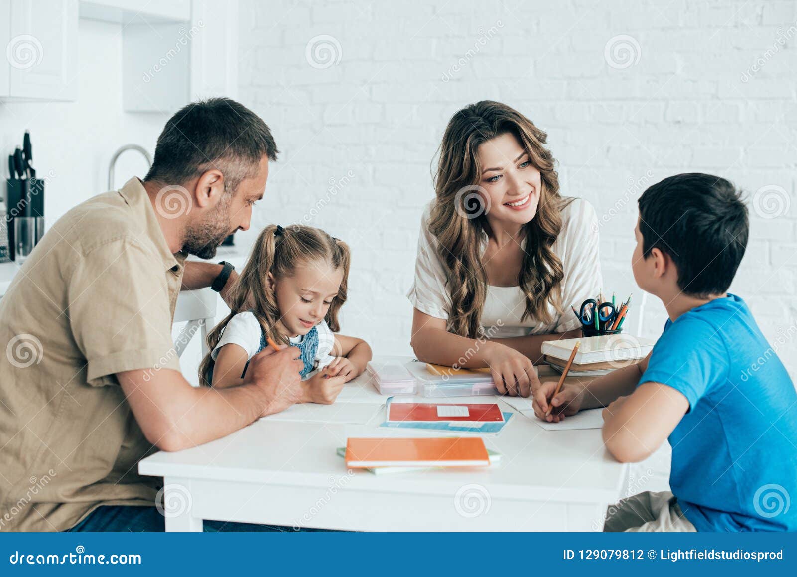 Parents Helping Children with Homework at Table Stock Photo - Image of ...