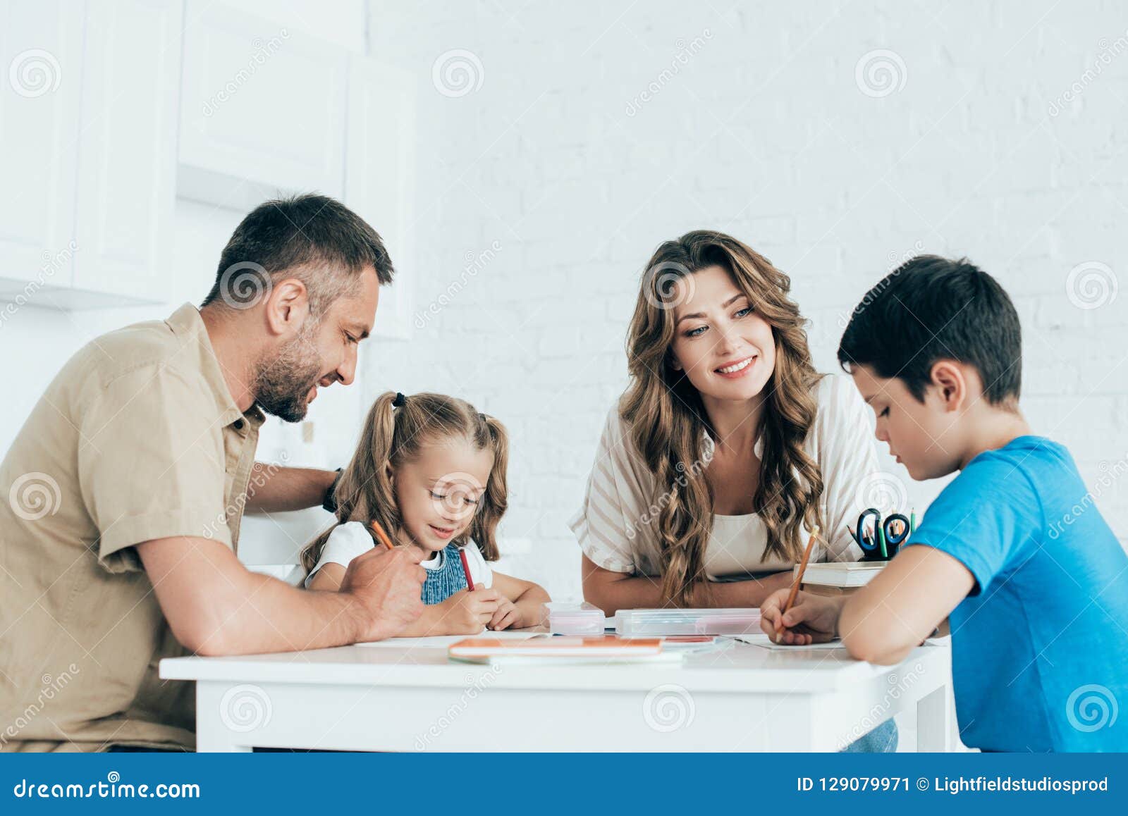 Parents Helping Children with Homework at Table Stock Image - Image of ...