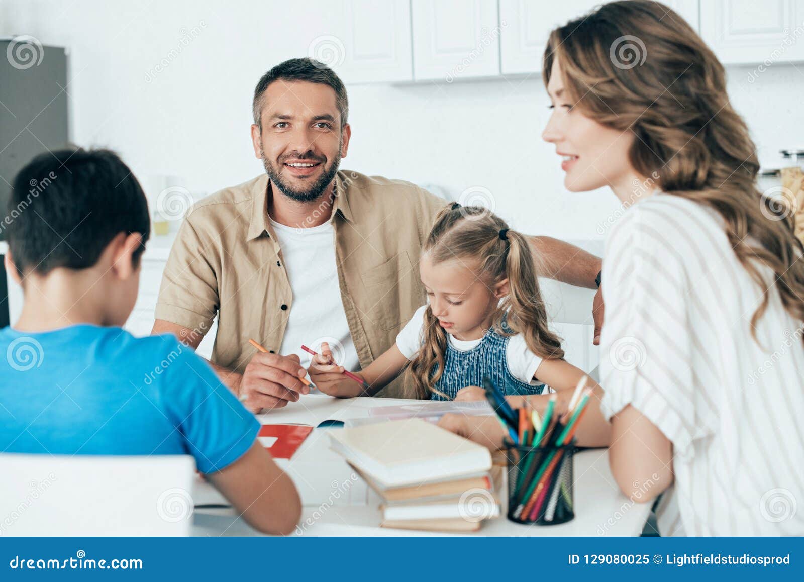 Parents Helping Children with Homework at Table Stock Image - Image of ...