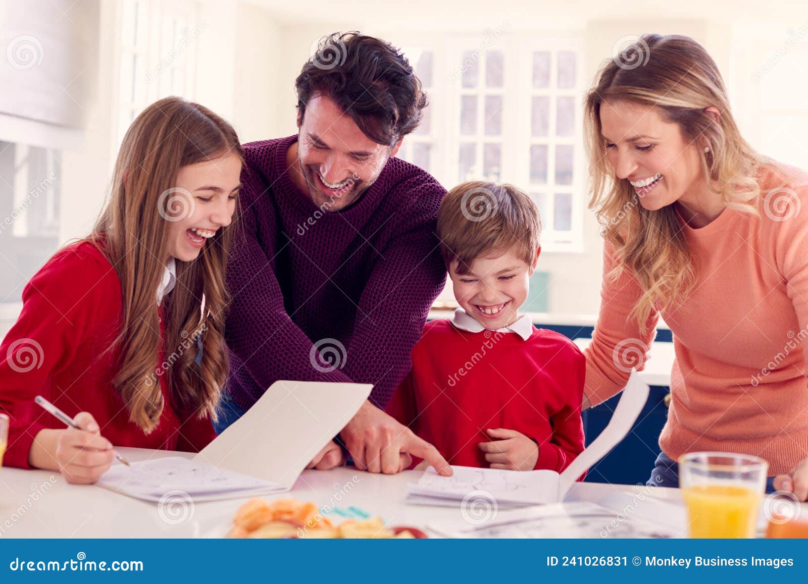 Parents Helping Children in School Uniform Doing Homework at Kitchen ...