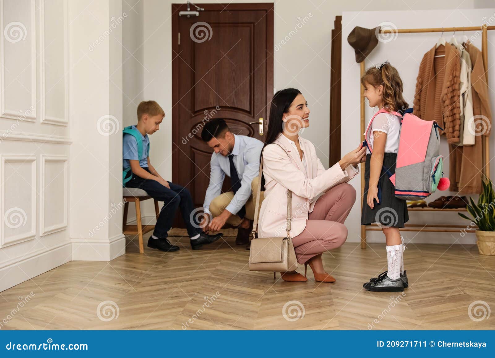 Parents Helping Their Children Get Ready for School in Hallway Stock ...