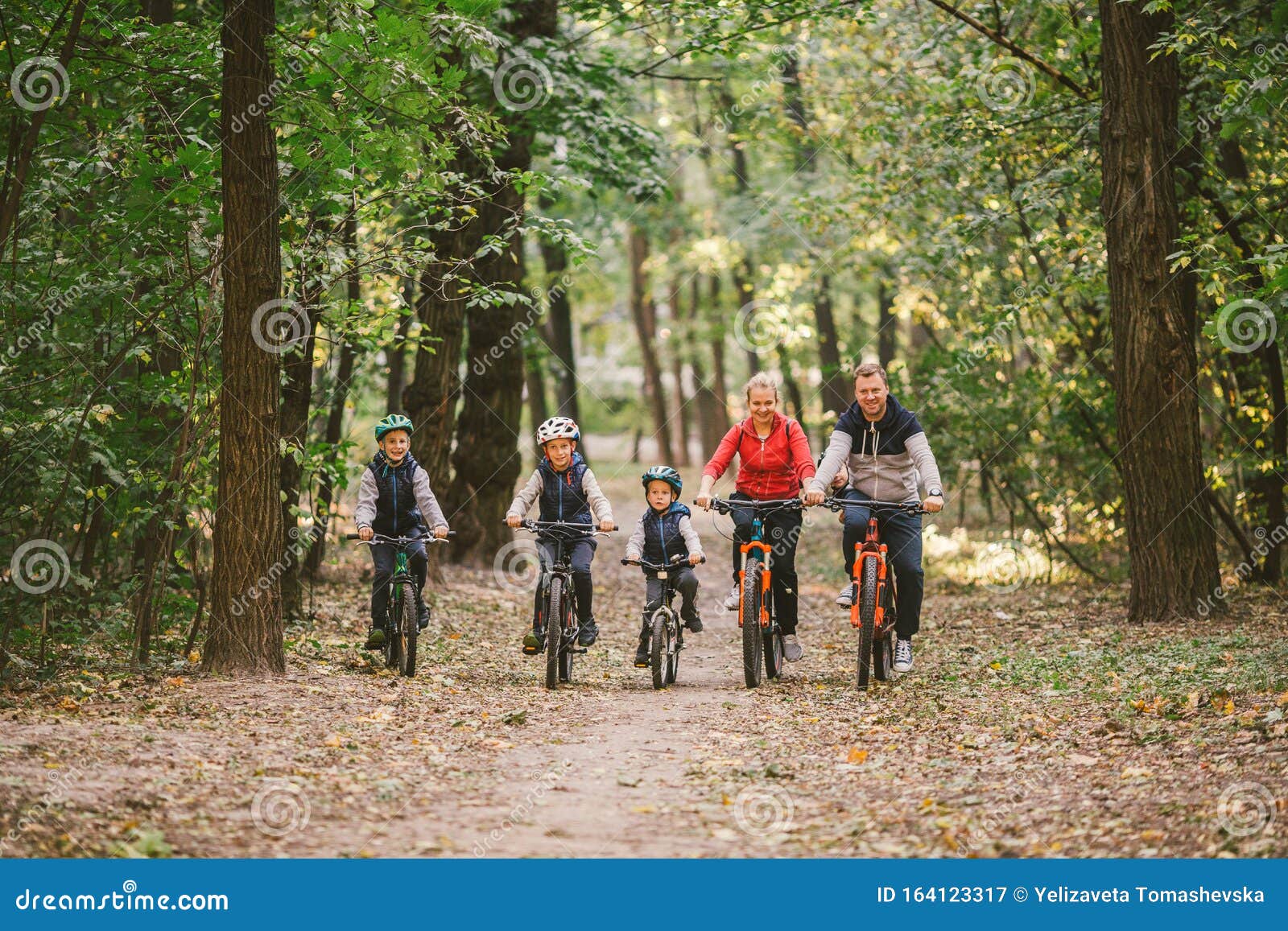 Parents and Kids Cycling on Forest Trail. Young Family Cycling in ... Parents and Kids Cycling on Forest Trail. Young Family Cycling in ...