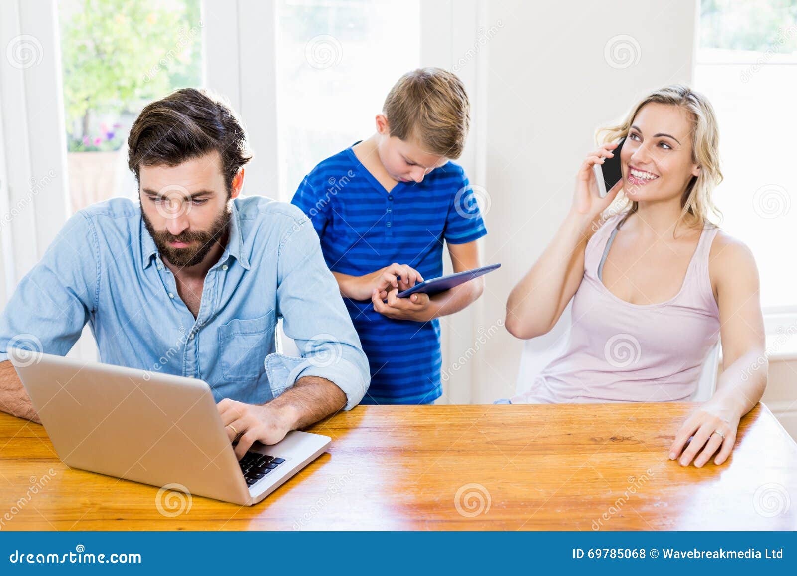 Parents and Son Using a Laptop, Tablet and Phone Stock Photo - Image of ...