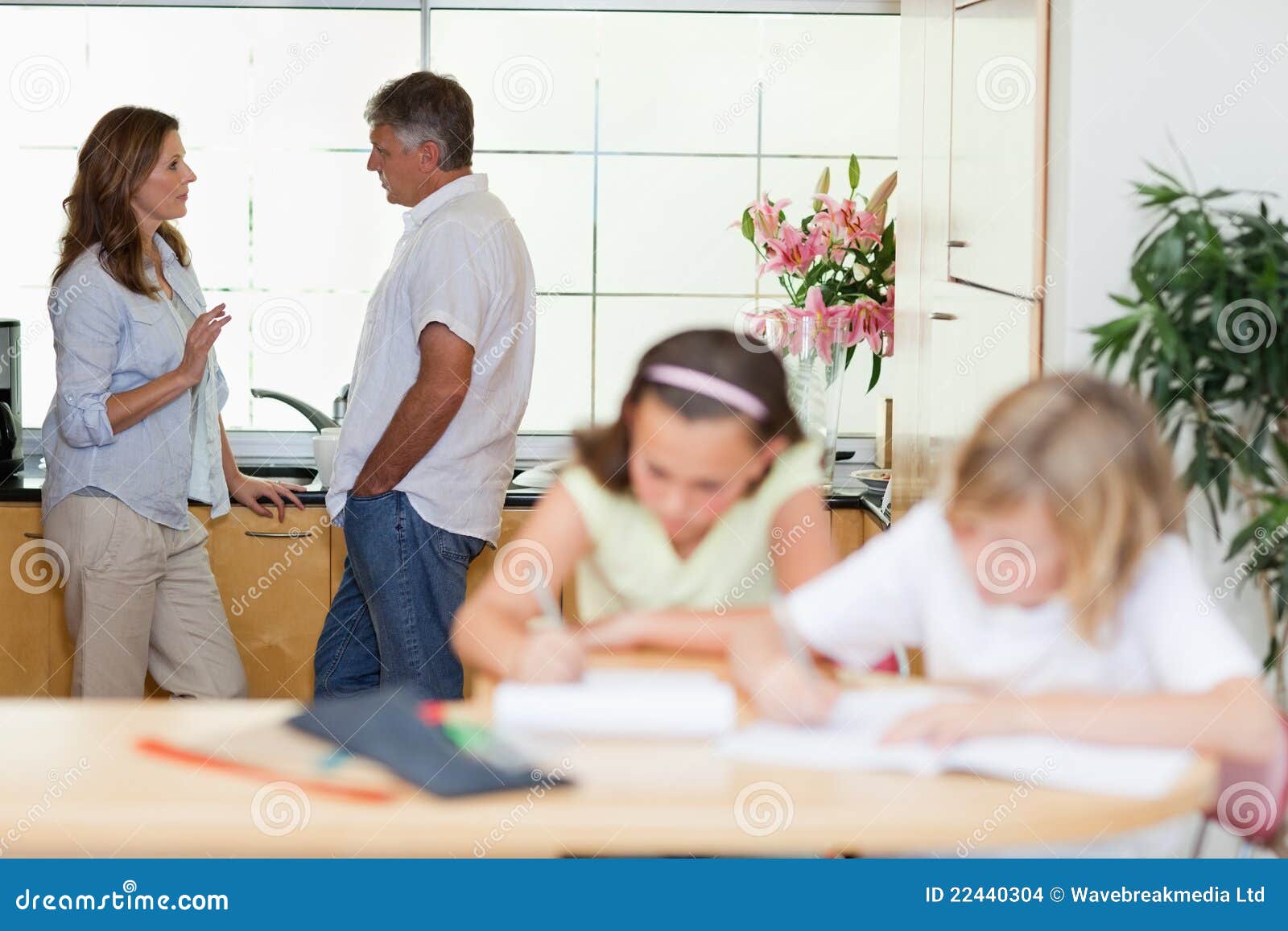 Parents Talking With Children Doing Homework In Front Of Them Stock ...