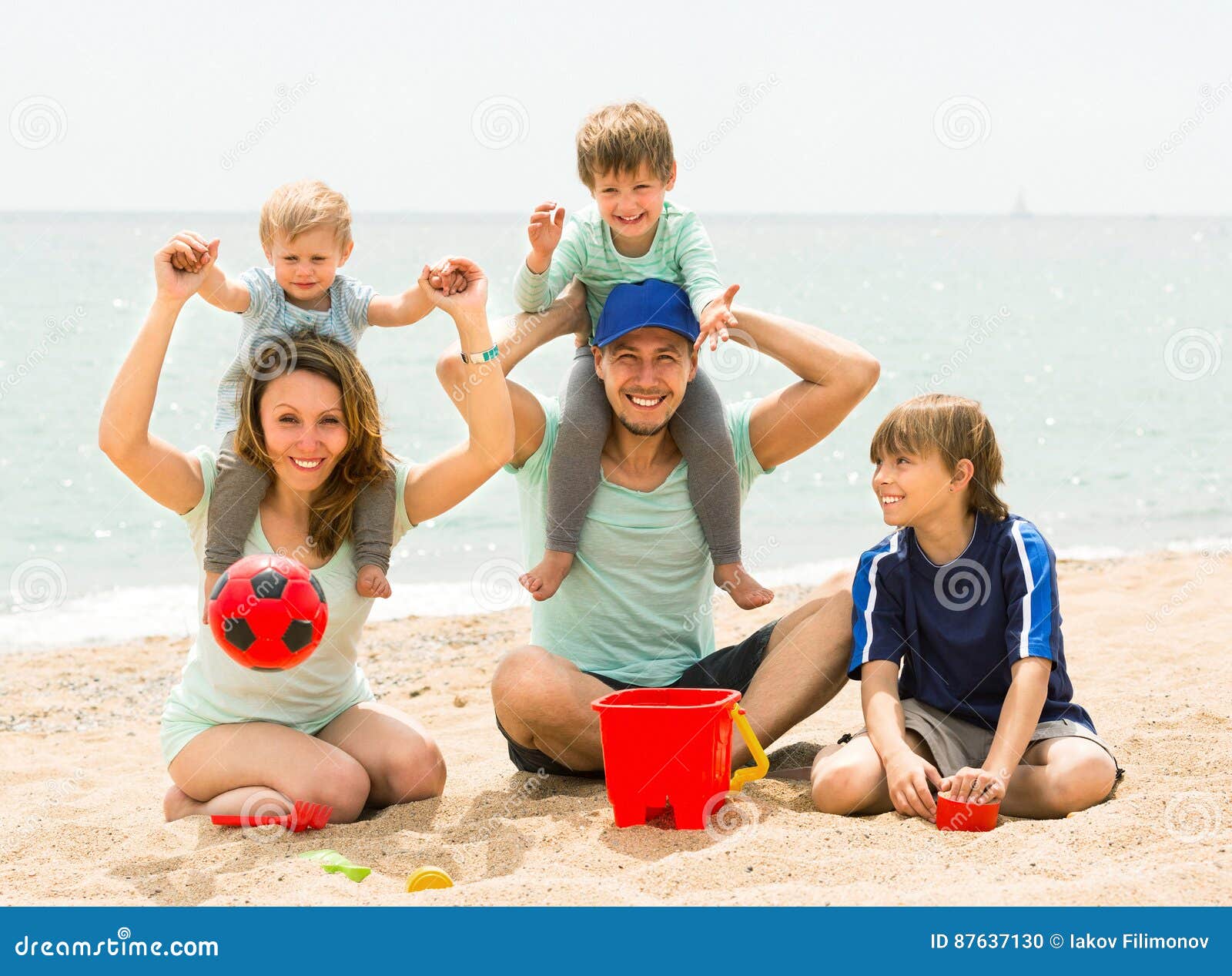 Parents with Three Children on the Beach Stock Photo - Image of game ...
