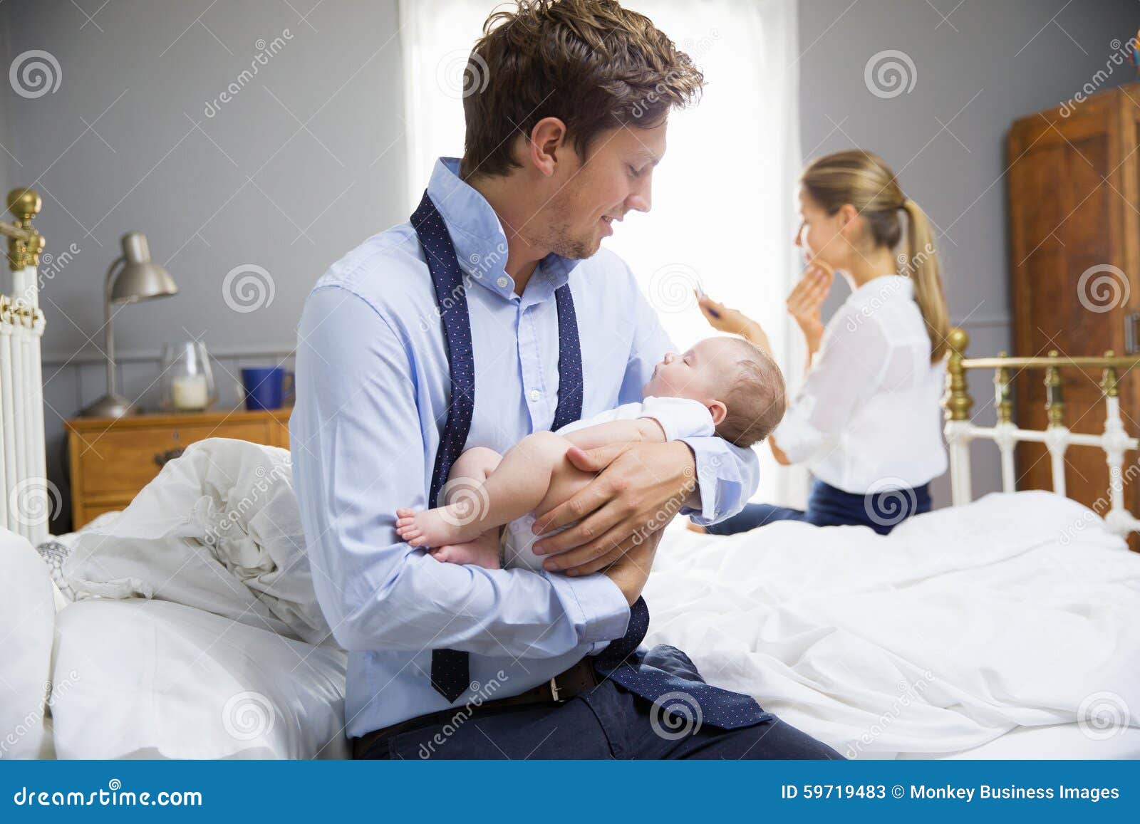 Parents with Young Baby Dressing for Work in Bedroom Stock Image ...