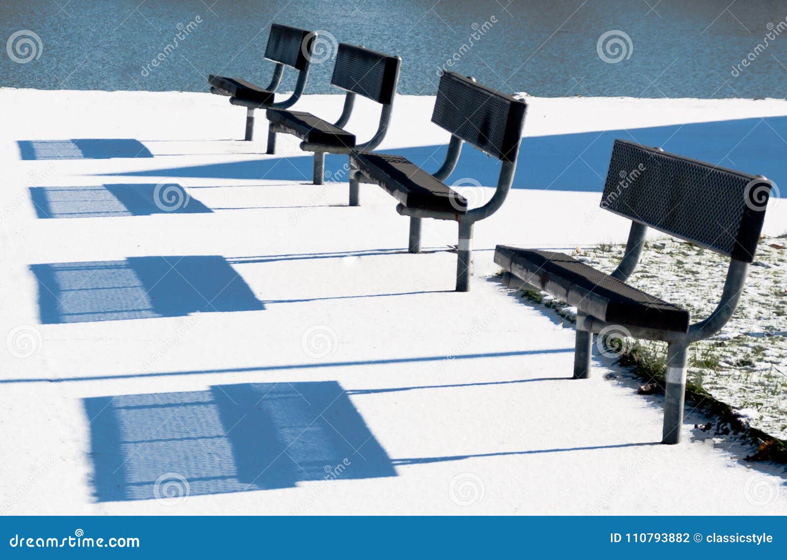 Park Benches Casting Shadows on a Light Dusting of Show Stock Photo ...