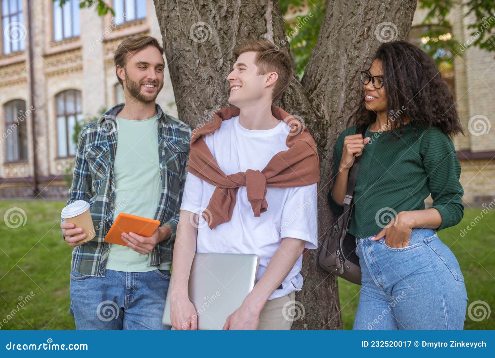 Young People Standing Near the Tree in the Park Stock Image - Image of ...