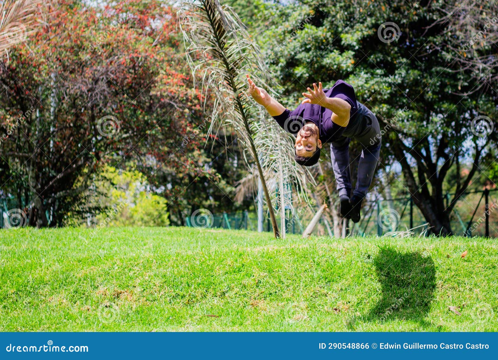 Young Man Doing a Back Flip in a Park, Practicing Gymnastics Outdoors ...