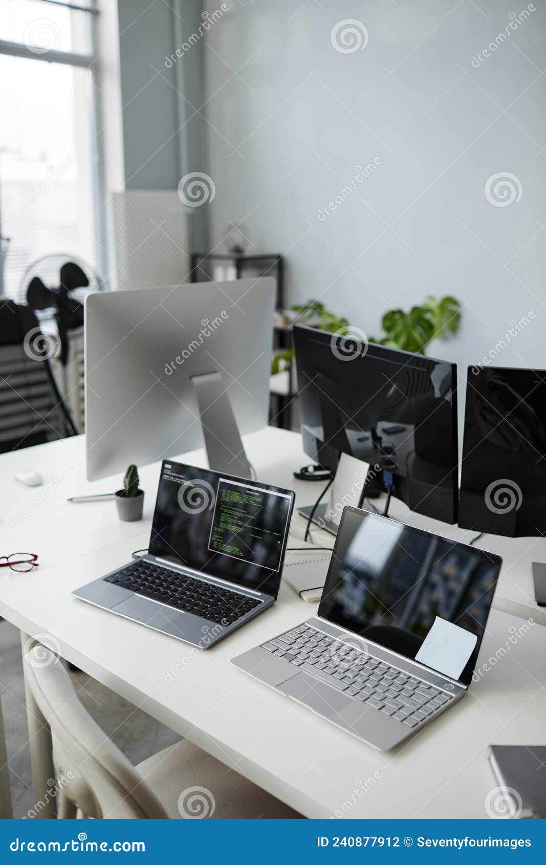 Part of Office with Group of Laptops and Computer Monitors on Desks ...