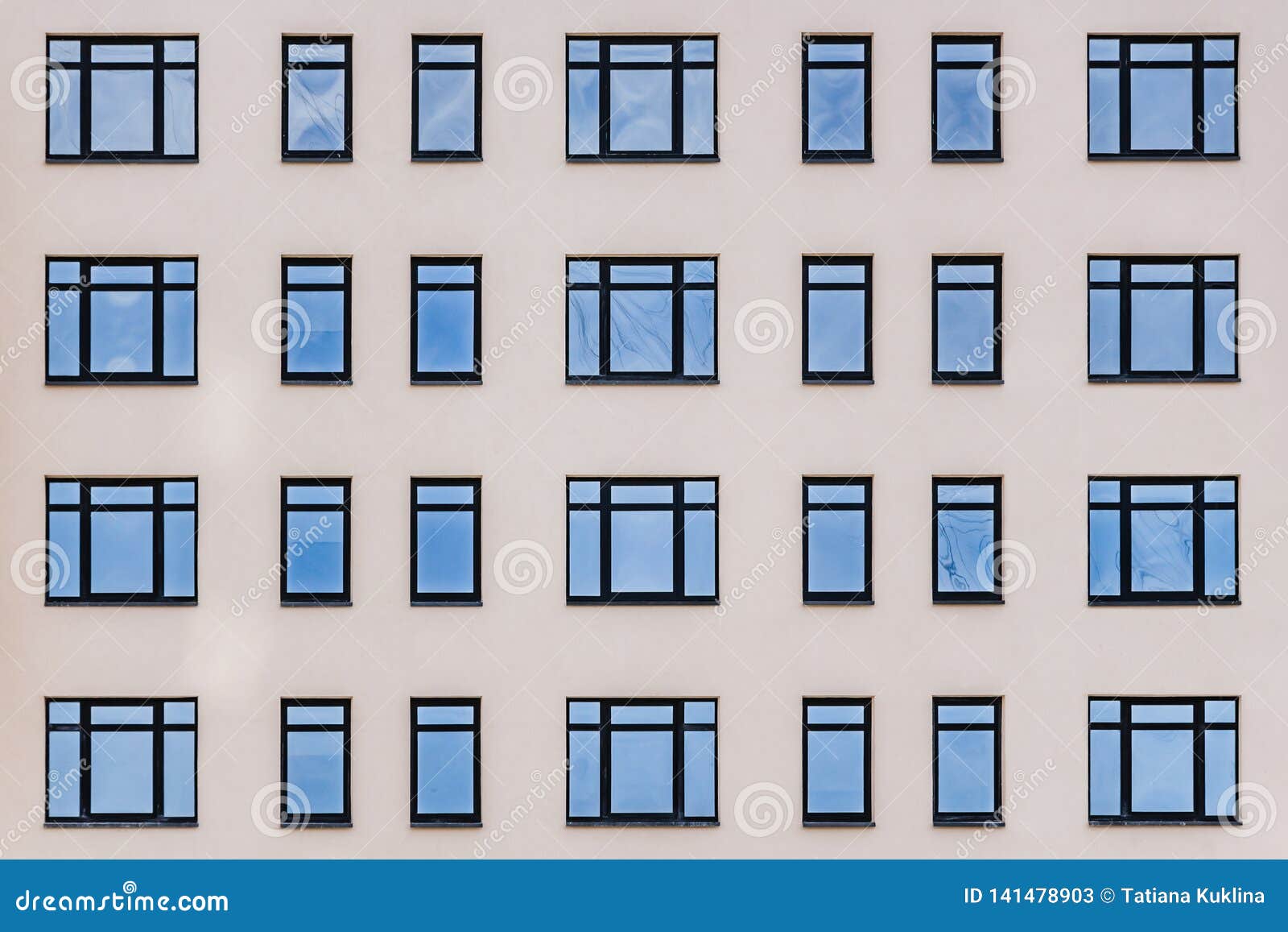 A Part of a Yellow Wall with Blue Windows with Reflections of Blue Sky ...