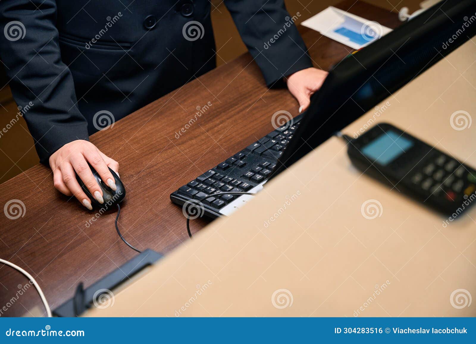 Partial of Female Receptionist Using Computer at Reception Desk in ...