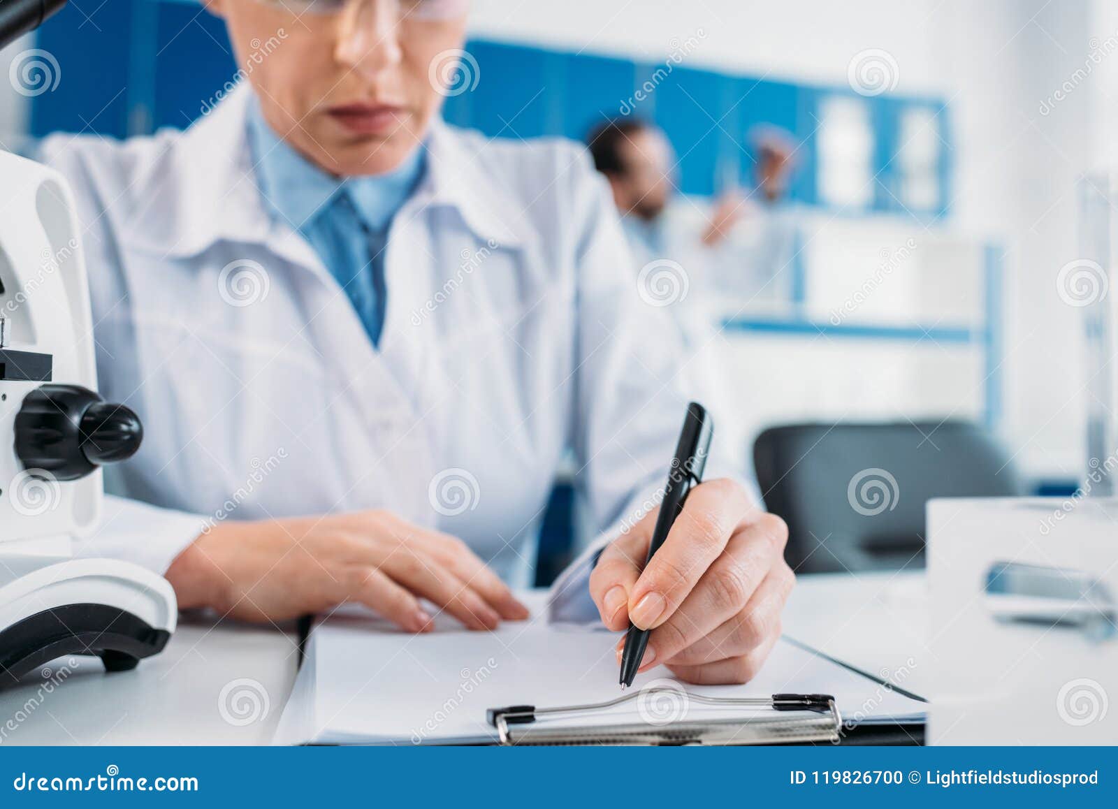 Partial View of Female Scientist Making Notes in Notepad at Workplace ...