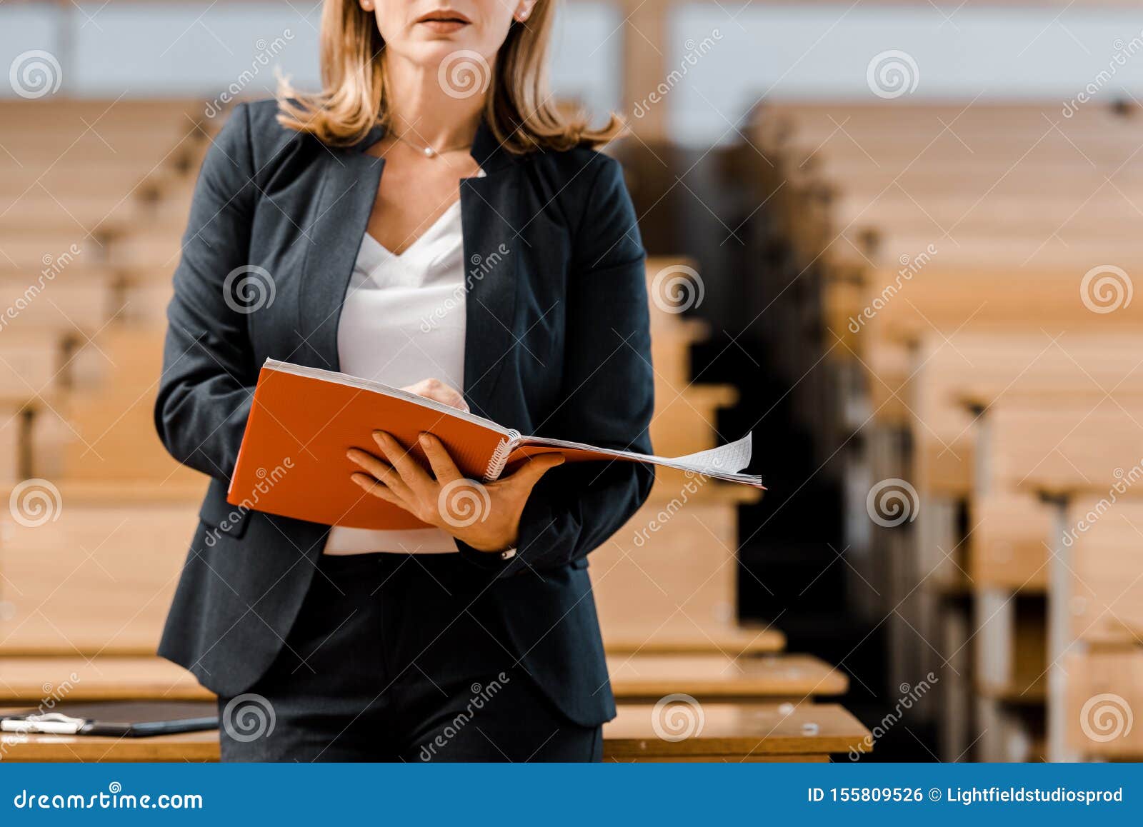 Partial View of Female University Professor Holding Journal and Writing ...